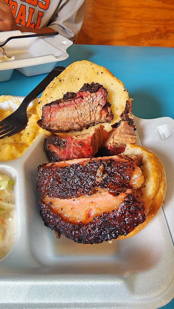 The brisket sandwich – where smoke-kissed meat meets humble bread in a romance that puts most rom-coms to shame.