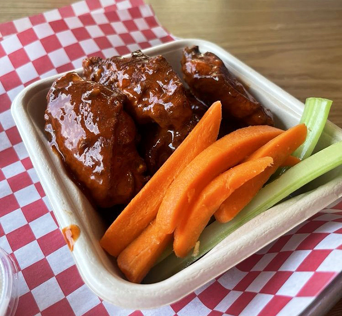 Even the wings get the royal treatment—glossy, sticky-sweet sauce with the classic carrot and celery sidekicks standing by for cooldown duty.