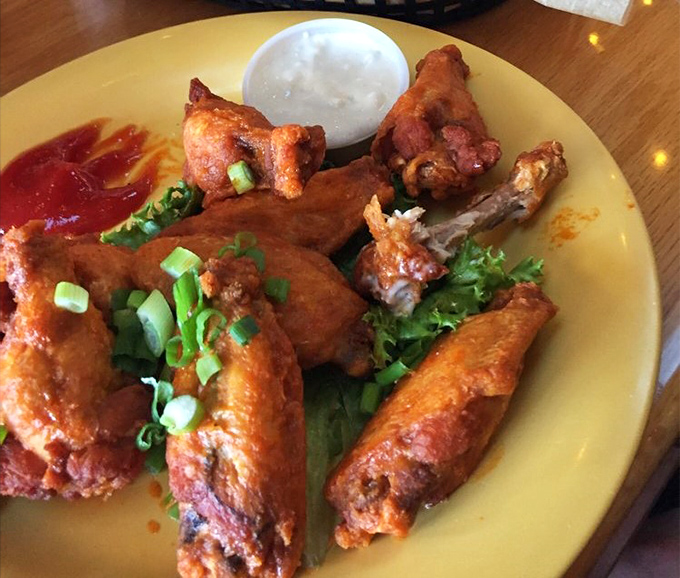 Buffalo wings that don't mess around – crispy, saucy, and garnished with green onions that add a fresh pop to this bar food classic.