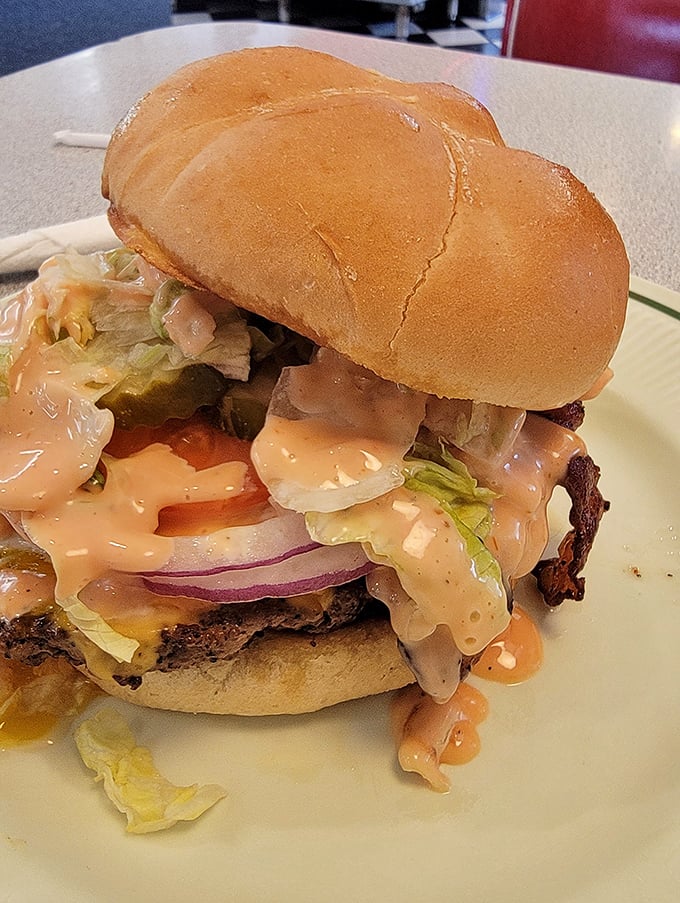 A burger that doesn't need fancy aioli or truffle oil to impress—just honest ingredients stacked high enough to require jaw exercises.