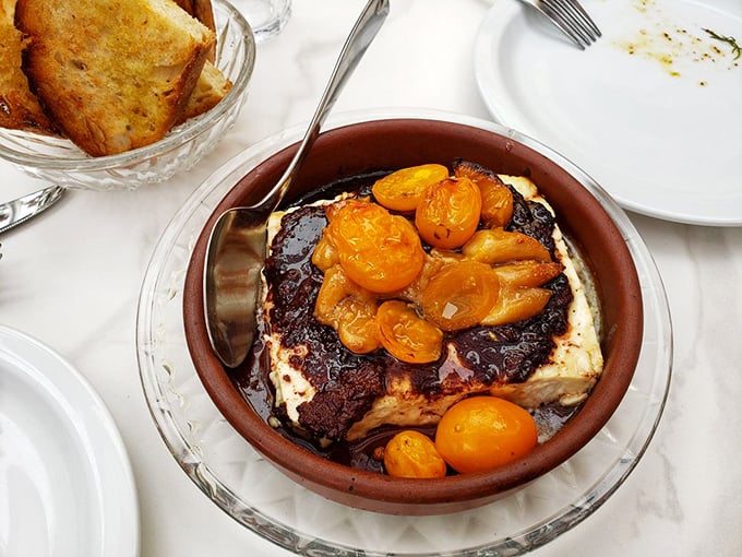 This isn't just burrata—it's a creamy cloud resting on a bed of roasted tomatoes, waiting to be smeared on crusty bread and transported directly to food heaven.