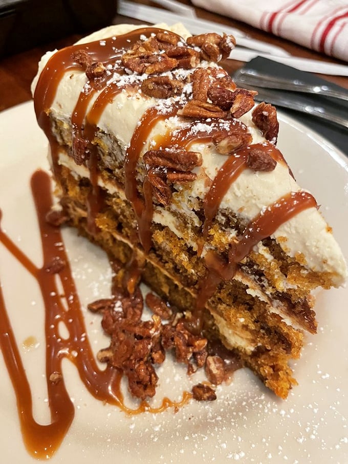 This isn't just carrot cake—it's an architectural masterpiece of cream cheese frosting, candied pecans, and caramel that demands to be photographed before devoured.