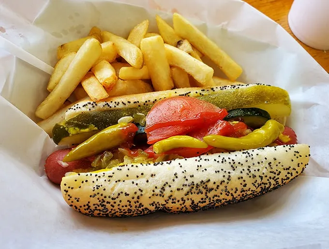 The Chicago-style hot dog in its natural habitat—dragged through the garden and nestled beside hand-cut fries. Not a bottle of ketchup in sight.