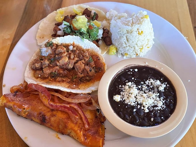 Tacos that tell a story with each bite, served alongside black beans dusted with queso fresco—a plate that speaks fluent delicious.