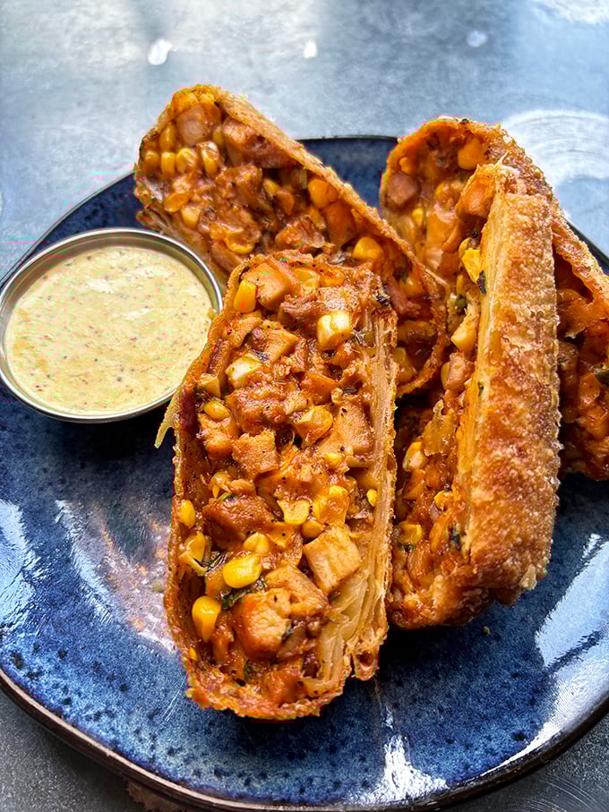 These aren't just egg rolls – they're crispy treasure chests filled with chicken and corn, served with a dipping sauce that'll make you consider drinking it straight.