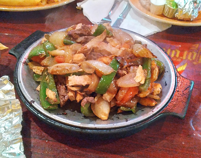 Sizzling fajitas that announce their arrival before you see them—a symphony of chicken, peppers, and onions performing on a hot skillet.
