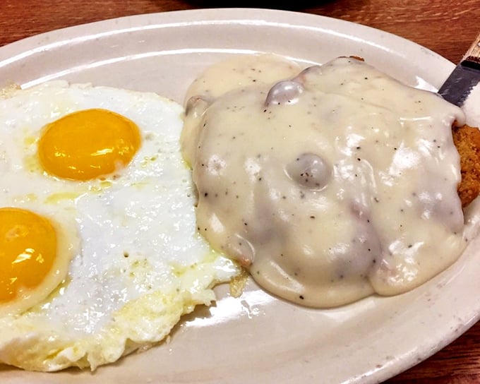 Chicken fried steak smothered in gravy alongside sunny-side-up eggs. This plate doesn't just feed you—it hugs your soul on a cellular level.
