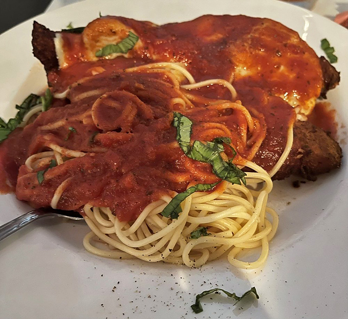 The legendary Chicken Parmesan—where crispy meets saucy meets cheesy in a trifecta that would make any Italian grandmother weep with joy.