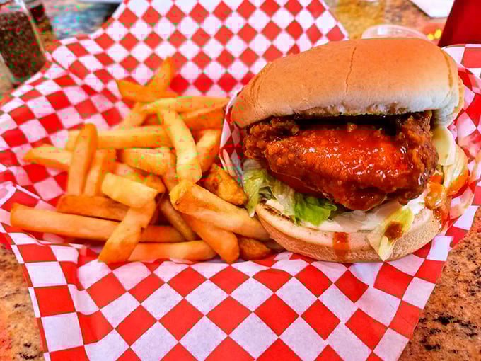 Buffalo chicken sandwich that brings the heat without setting your mouth on fire – served on a red checkered paper that screams "diner classic."
