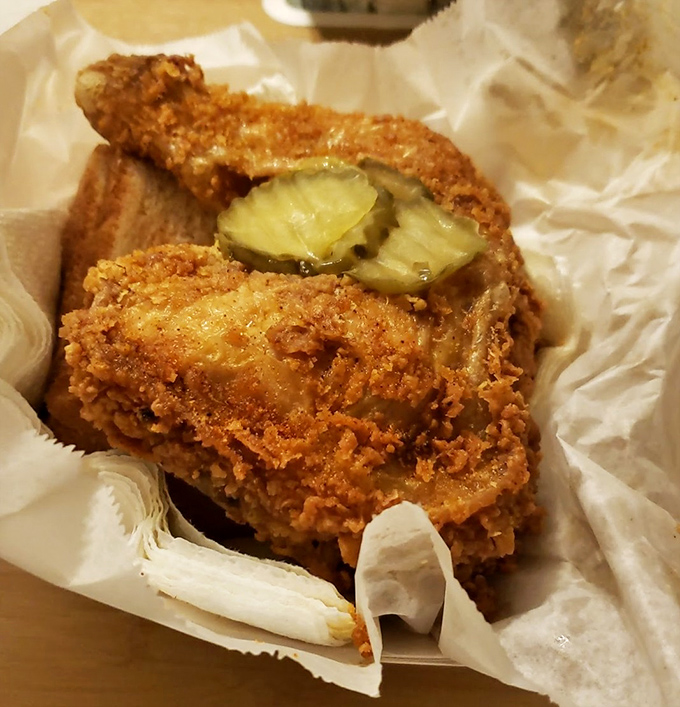 Golden-fried perfection with pickle chips standing guard. This isn't just chicken—it's Nashville's culinary legacy wrapped in crispy, spice-laden armor.
