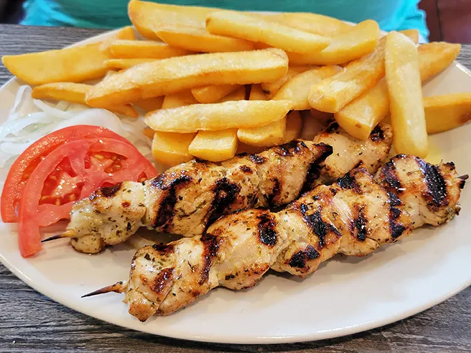 Perfectly grilled chicken souvlaki with crispy fries – comfort food that would make your Greek grandmother weep with joy.