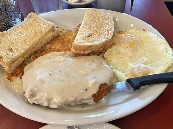Country gravy blankets this chicken fried steak like a comforting hug from your favorite aunt—the one who never worried about cholesterol.
