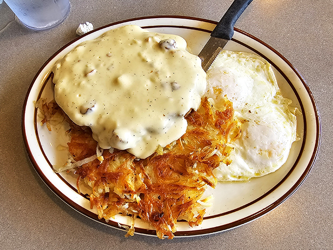 Country gravy cascading over crispy chicken fried steak like a delicious waterfall. The hash browns are practically begging for a fork.