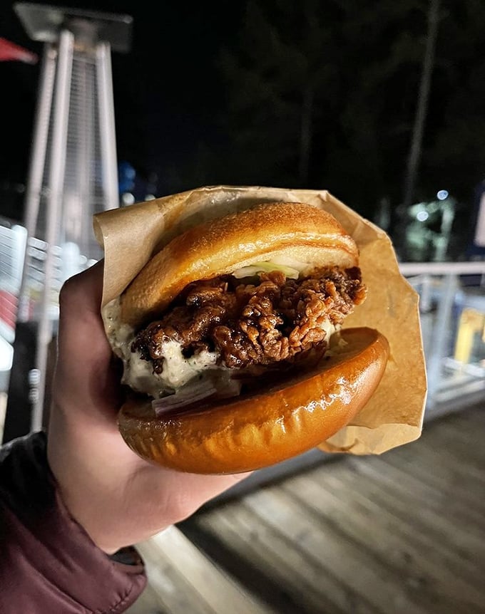 This isn't just a chicken sandwich—it's architecture. The golden bun barely containing that crispy, sauce-glazed masterpiece deserves its own blueprint. 