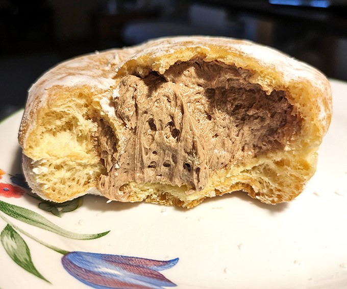 Behold the cross-section of donut perfection – where pillowy dough meets creamy chocolate filling in a marriage made in pastry heaven.
