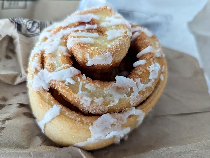 The cinnamon roll glistens with icing like it's auditioning for a pastry calendar—the kind of breakfast indulgence worth setting your alarm for.