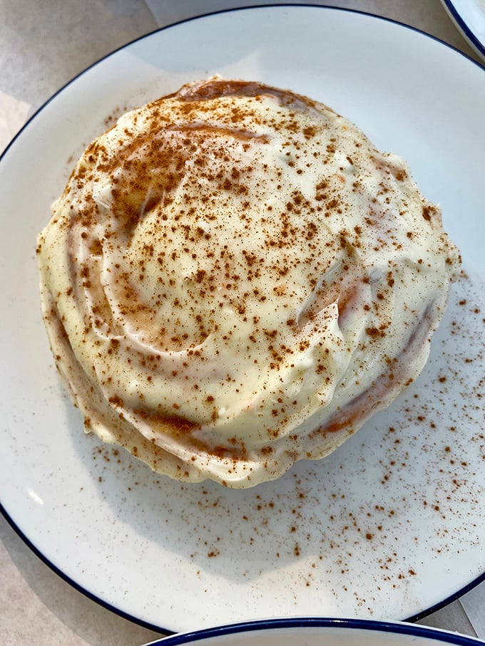 This cinnamon roll isn't just breakfast—it's an event. Swirls of cinnamon, clouds of cream cheese frosting, and a sprinkle of spice that whispers, "Take your time with me."