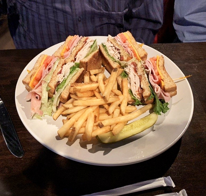 The club sandwich – that three-story architectural marvel of bread, meat, and vegetables that requires a dislocated jaw to consume properly.