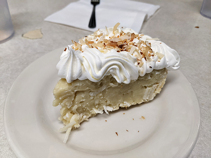 Coconut cream pie that would make your grandmother both proud and jealous. That towering meringue isn't just a topping—it's a statement.