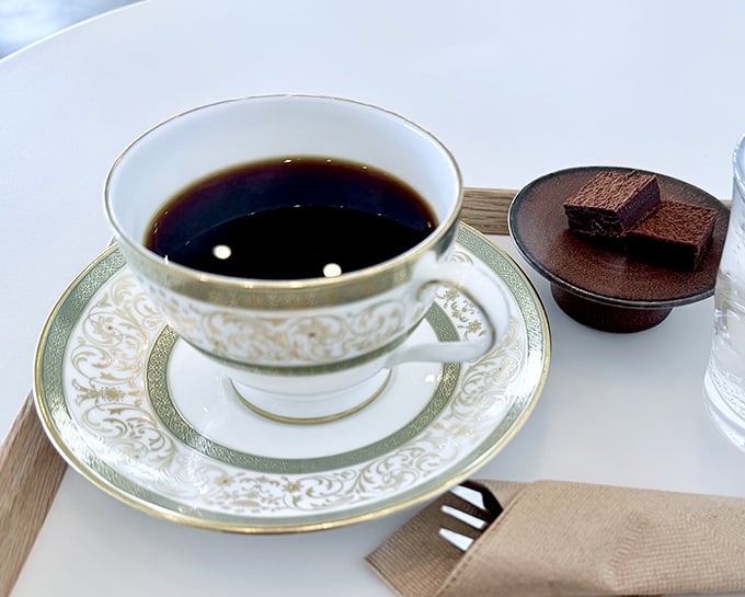 Elegance in a teacup that would make your grandmother proud. That chocolate square isn't a garnish—it's a companion for your journey.