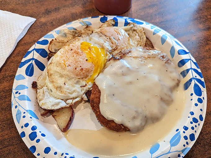Country fried steak smothered in gravy with a sunny-side-up egg standing guard. This plate doesn't care about your diet – it cares about your happiness.