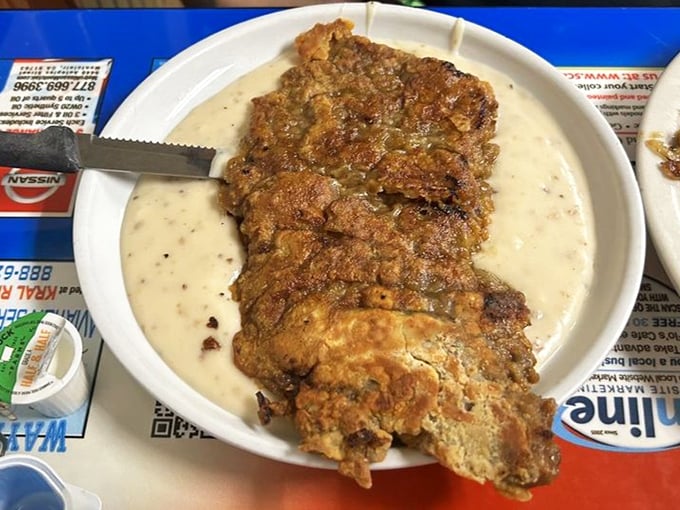 Country fried steak swimming in gravy—a dish so gloriously excessive it makes moderation seem like a terrible life choice.