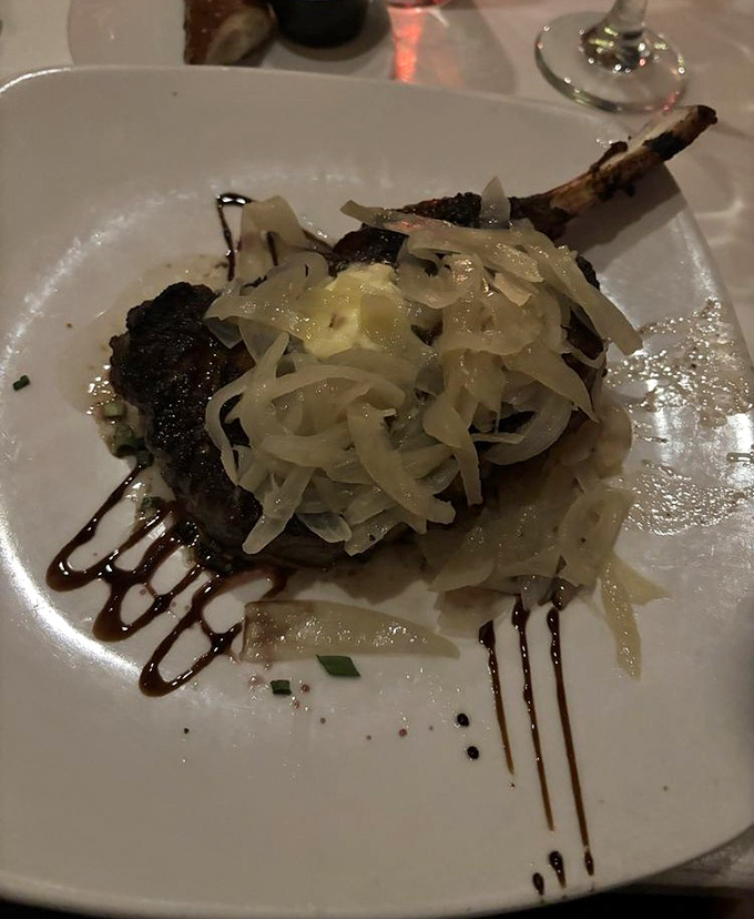 Meat masterpiece topped with caramelized onions that melt like butter. The artful sauce drizzle isn't just decoration—it's edible calligraphy.