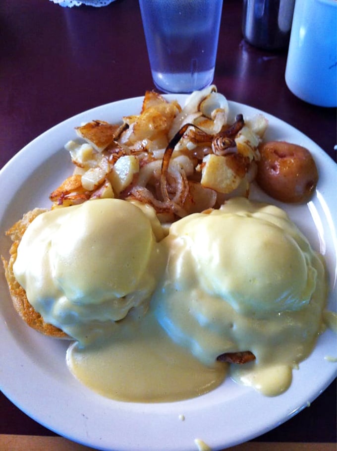 Eggs Benedict elevated to art form – those twin golden domes of hollandaise conceal treasures beneath. The potatoes look like they're having their own delicious party.