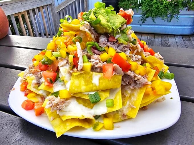 These crab nachos aren't just an appetizer, they're an architectural achievement—layers of tortilla chips, crab meat, and colorful toppings reaching skyward.
