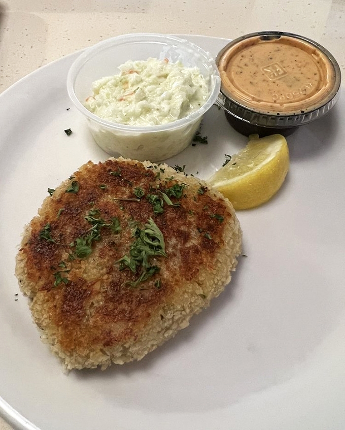 A golden-brown crab cake that doesn't hide behind fillers—just pure crab meat with a crispy exterior that shatters with each delicious bite.