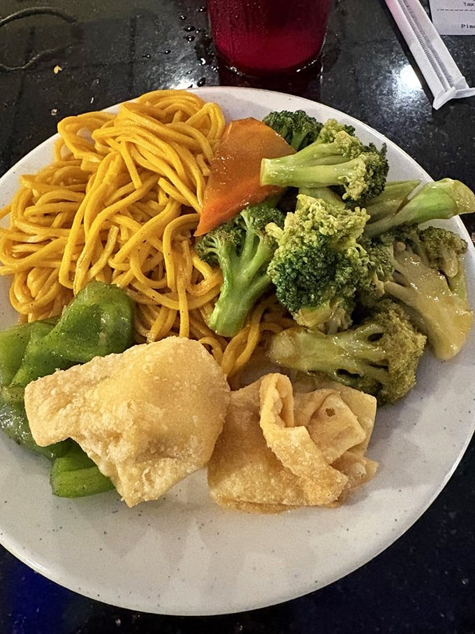A plate that tells the story of Chinese-American cuisine – golden lo mein noodles playing supporting role to crispy wonton stars.