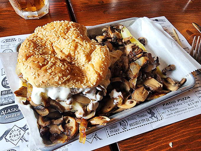 A burger that requires both hands, several napkins, and possibly a signed waiver. Those mushrooms aren't hiding—they're showing off.