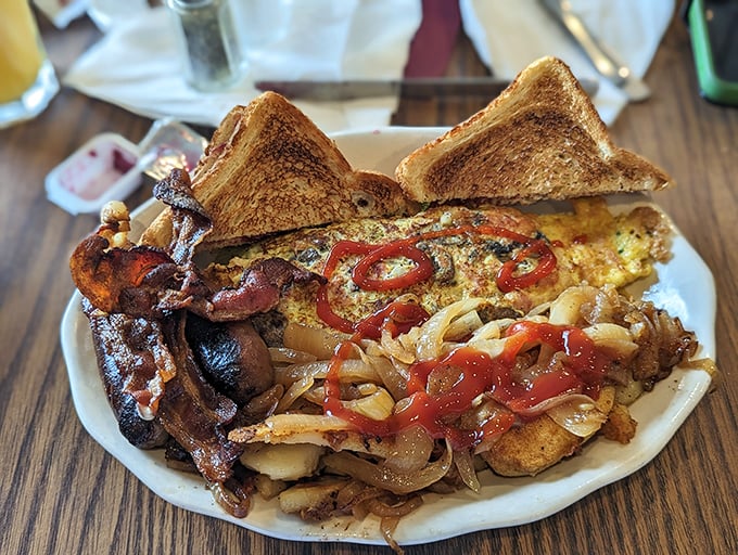 Breakfast architecture at its finest – crispy bacon, perfectly cooked eggs, and hash browns that strike the ideal balance between crisp and tender.