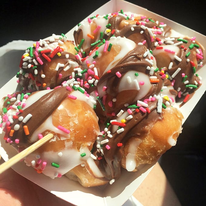 Donut holes elevated to star status with chocolate dips and rainbow sprinkles—proof that good things come in small packages.