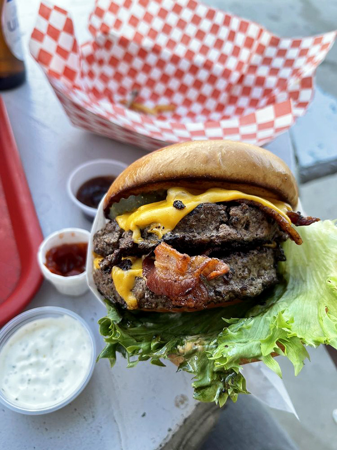 Not just a burger—a towering monument to beef perfection. The melted cheese cascades like a yellow waterfall over those perfectly charred patties.