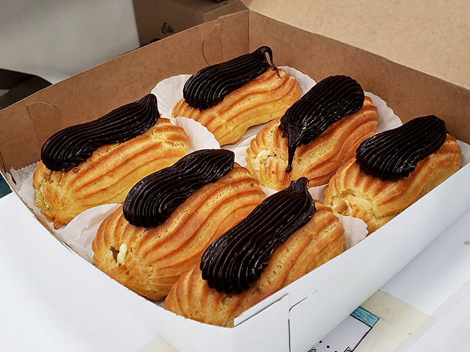 Eclairs lined up like delicious soldiers, their chocolate tops gleaming with the promise of custard treasures within.