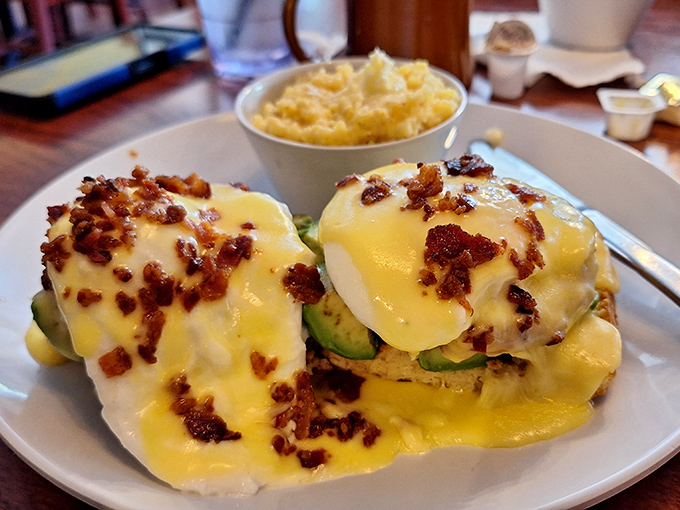 Eggs Benedict reimagined with avocado and bacon—a breakfast masterpiece that makes you wonder why you'd ever settle for a basic bowl of cereal again.