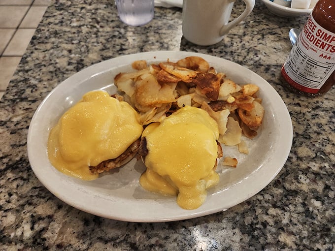Eggs Benedict gets the royal treatment here – hollandaise cascading like golden silk over perfectly poached perfection.