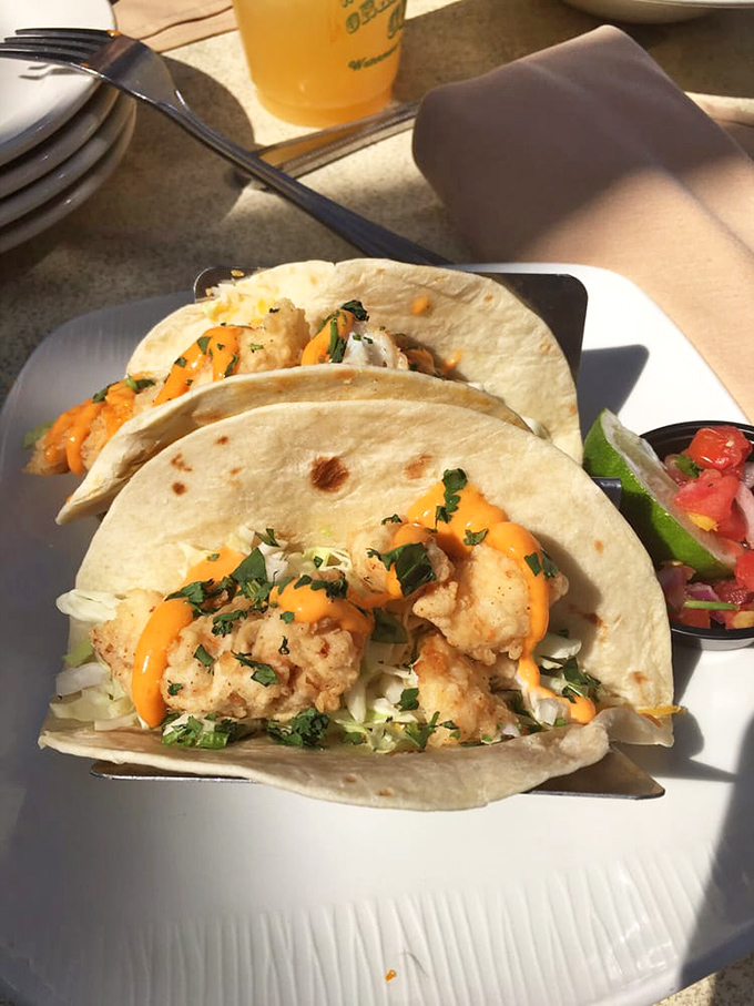 These fish tacos don't need a passport to transport you to paradise – crispy fish, vibrant mango slaw, and that signature orange sauce create vacation vibes.