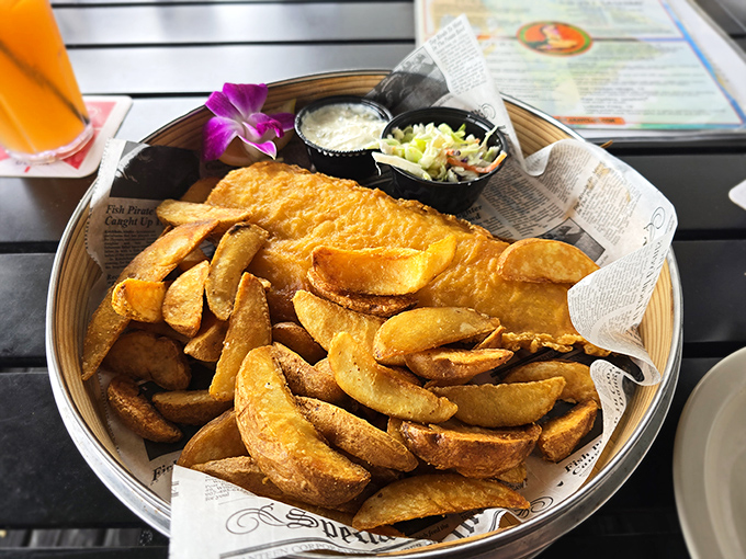 These aren't just any fish and chips—they're potato wedges with attitude, served with a purple orchid because even comfort food deserves to dress up occasionally.