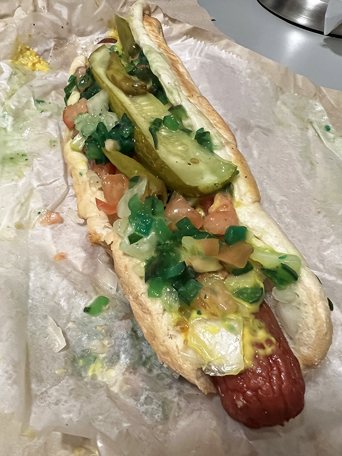 A foot-long masterpiece dressed to impress with pickles, tomatoes, and enough toppings to require structural engineering skills.