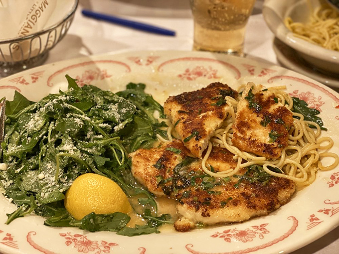 Perfectly seared chicken Francese lounging beside a bed of greens – like a culinary power couple that knows they look good together.