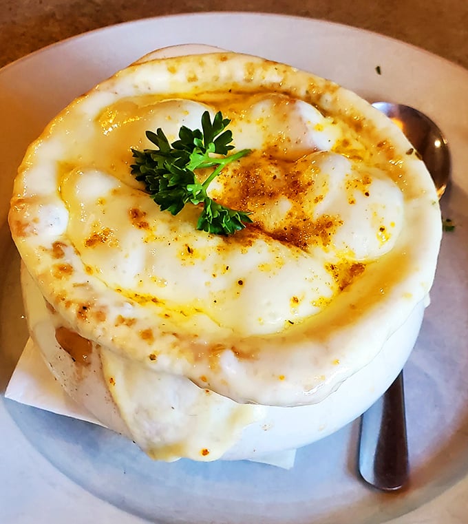 French onion soup done right—a bubbling cauldron of melted cheese and savory broth. The kind of comfort that makes winter almost welcome.