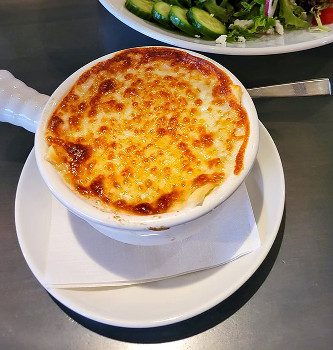 Bubbling cheese forms a golden canopy over this French onion soup, waiting to be broken like crème brûlée's savory cousin.