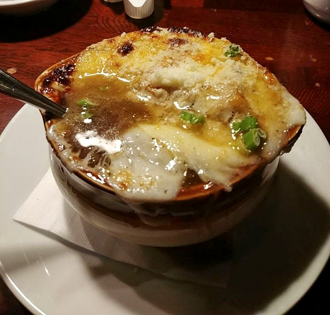 This isn't just French onion soup—it's a cheese-crowned masterpiece of savory comfort. The spoon-breaking crust signals greatness beneath.