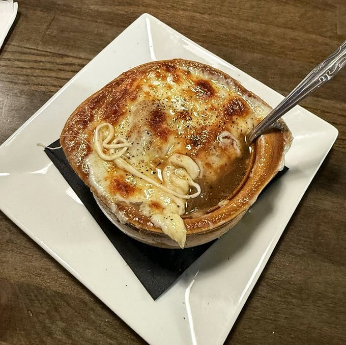French onion soup that's having an identity crisis as a hot tub for noodles. That golden, bubbly cheese top is practically begging for a spoon dive.
