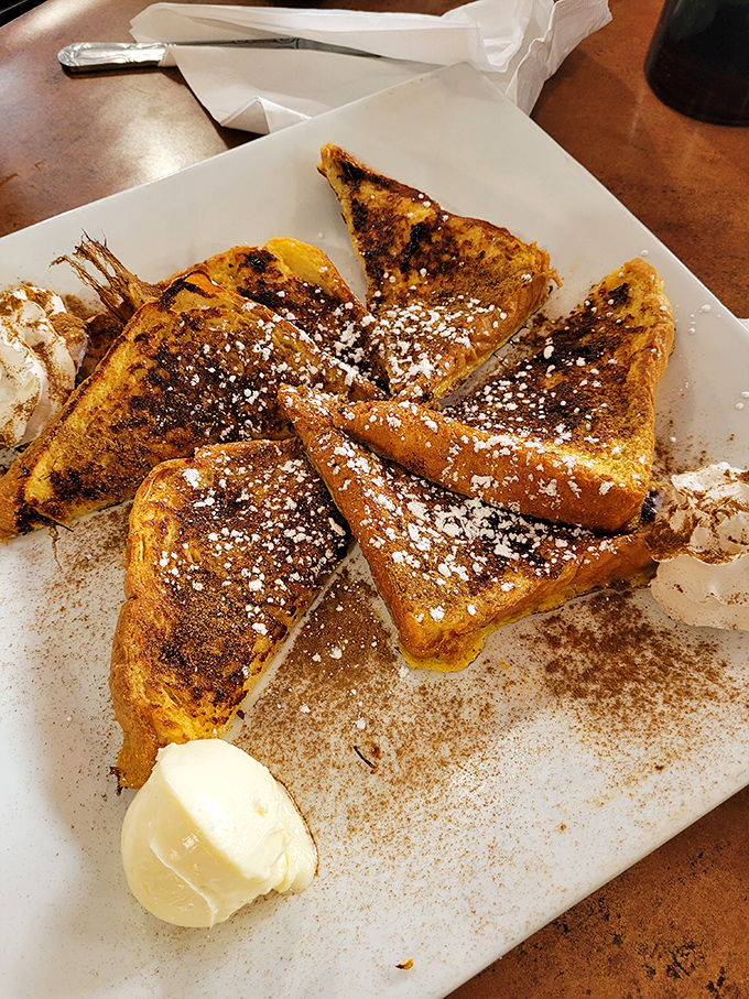 The French toast arrives looking like it just won a beauty pageant – golden, cinnamon-dusted, and ready for its close-up.