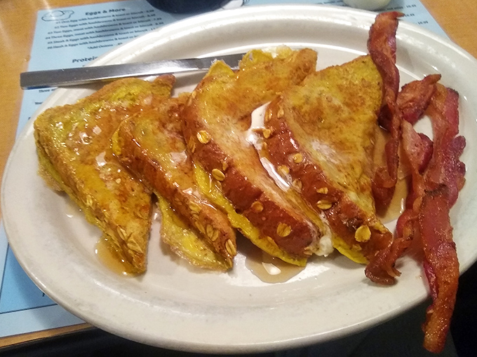 French toast that's achieved the golden ratio of crispy exterior and custardy interior. Those strips of bacon aren't just a side—they're essential supporting actors in this breakfast drama.