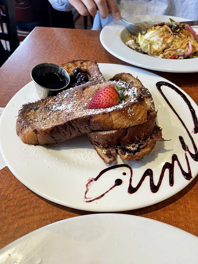 French toast that deserves its own Hollywood star—thick-cut cinnamon bread transformed into a caramelized masterpiece with artistic chocolate drizzles.