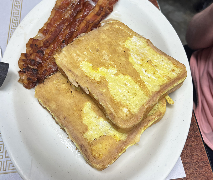 French toast that's achieved that mythical balance – crispy edges, custardy centers, and bacon cooked exactly how bacon should be.